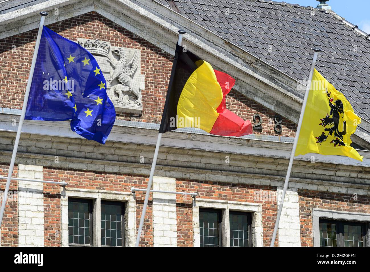 Three flags on a town hall facade - European flag - Belgian flag ...