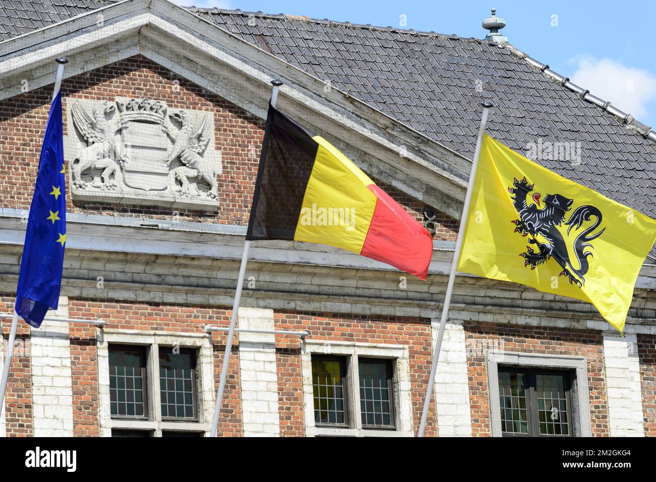 Three flags on a town hall facade - European flag - Belgian flag ...