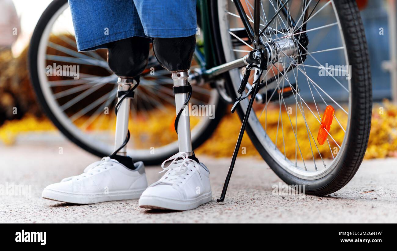 View of a man with prosthetic legs and white sneakers. Standing next to ...
