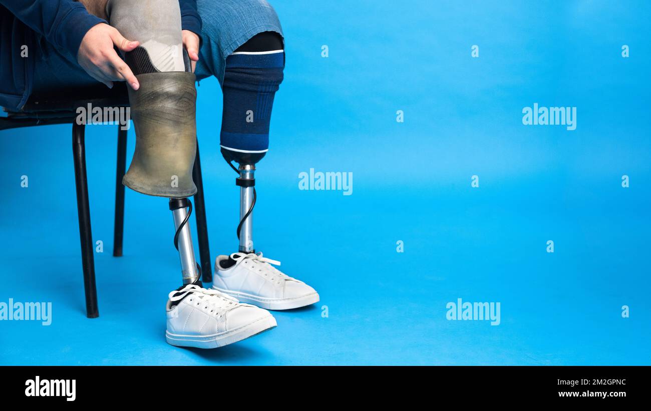 View of a man with prosthetic legs and white sneakers. Removing the ...