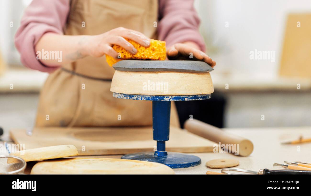 The master of sculpting pottery working in a studio. Giving a rounded ...