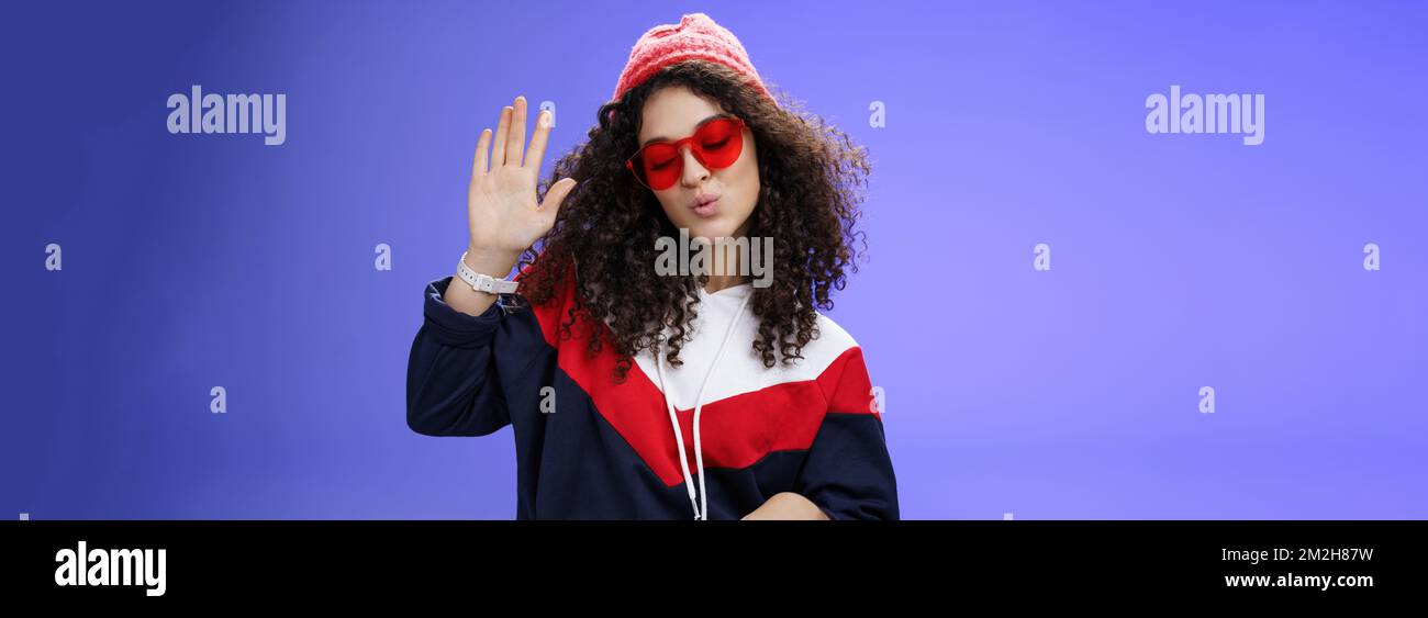 Studio shot of cool and stylish dj girl in red beanie and sunglasses ...