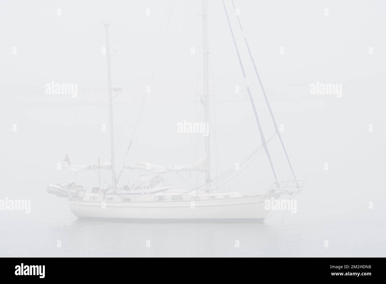 Sailboat / sailing boat / yacht with lowered sails anchored at sea ...