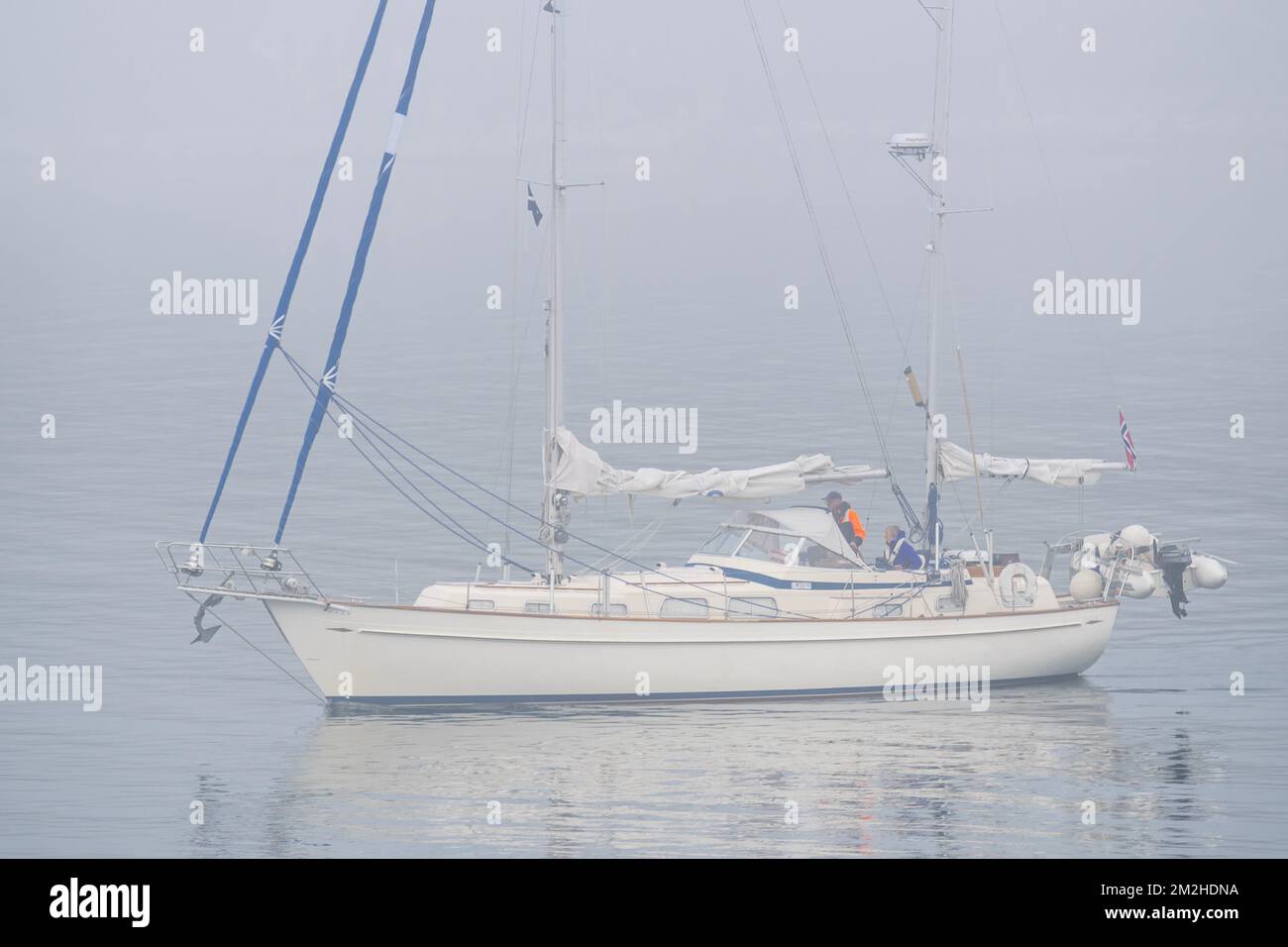 Sailboat / sailing boat / yacht with lowered sails at sea during bad ...