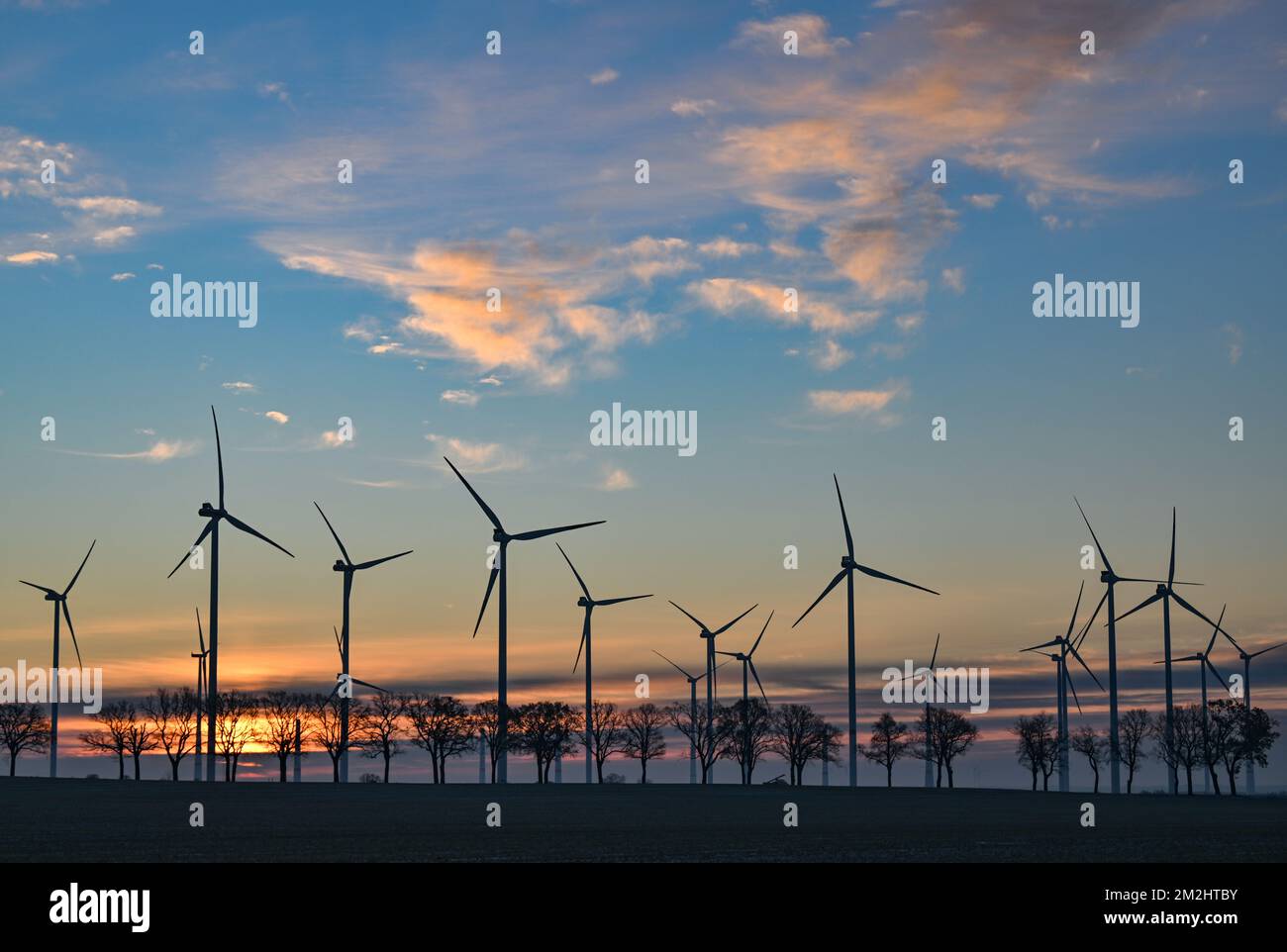 Sieversdorf, Germany. 14th Dec, 2022. Sunrise behind the wind energy ...