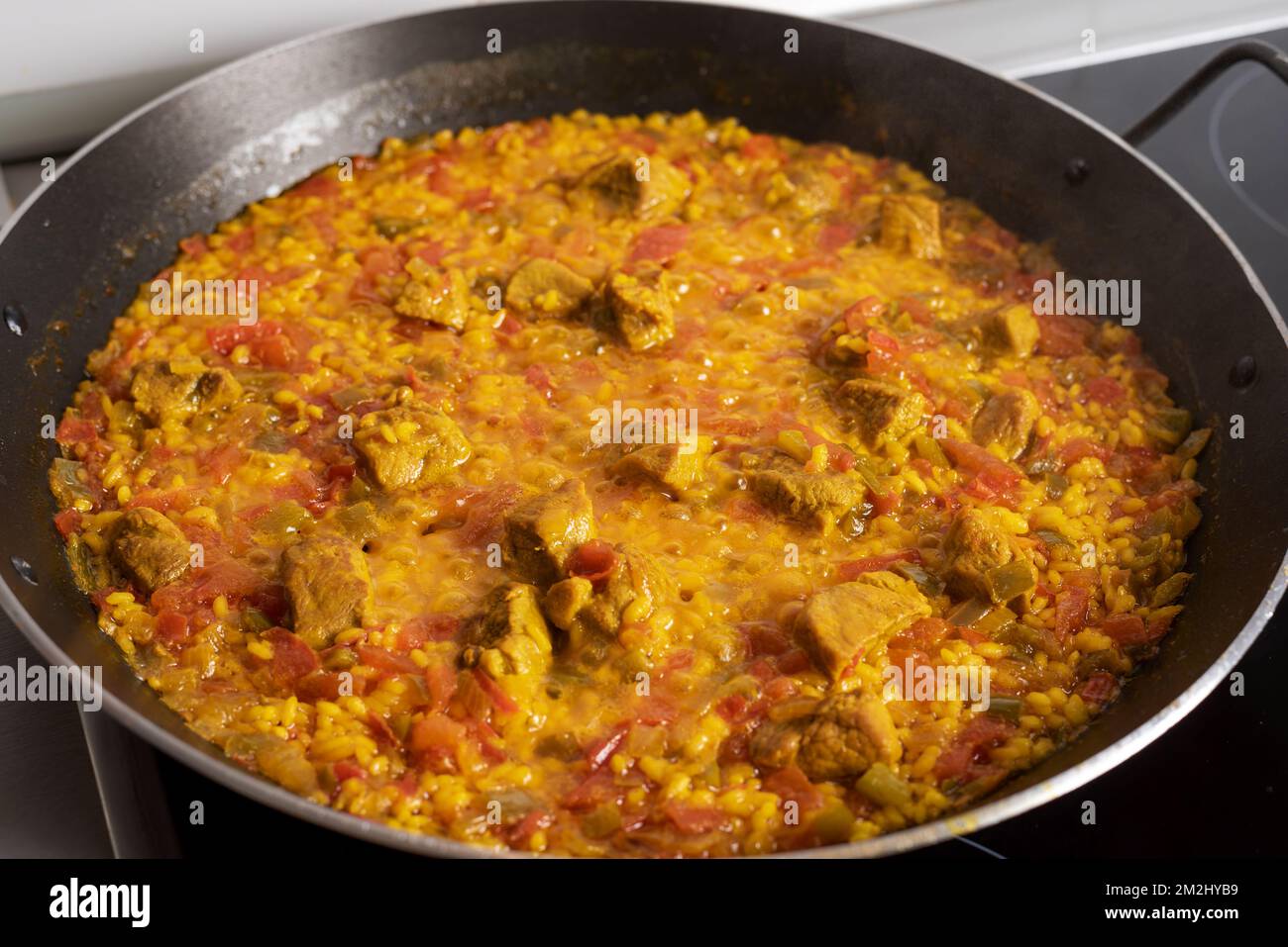 Pan with a meat paella about to be removed from the heat Stock Photo ...