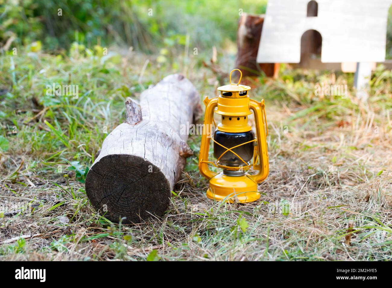 Defocus closeup of old fashioned yellow oil lamp on green nature ...