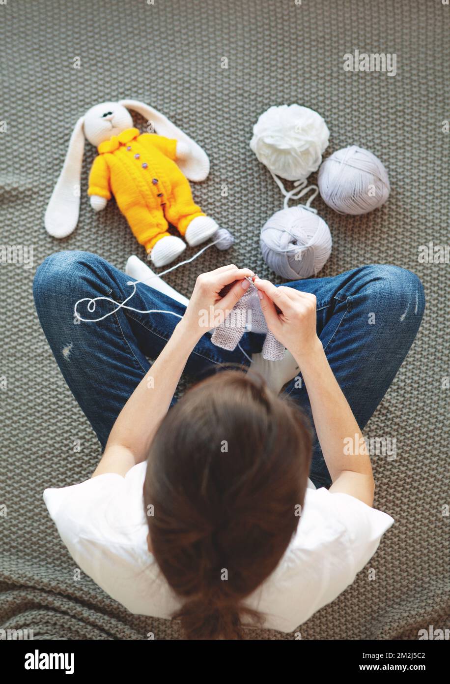 Handmade and crafting. Woman knitting for easter bunny, sitting on ...