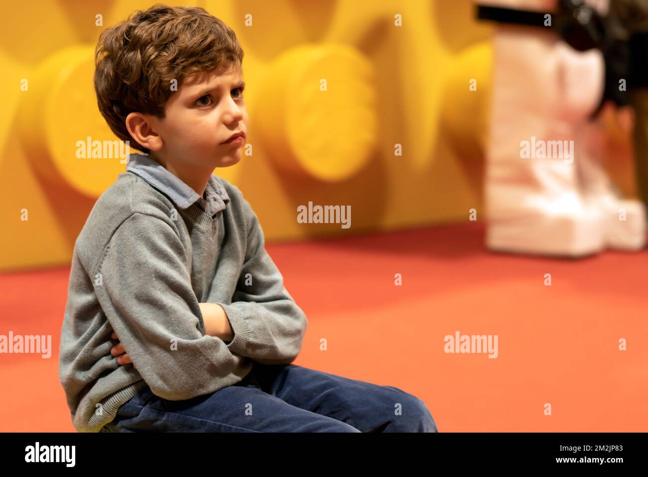Unhappy boy in casual clothes crossing arms and looking away while ...