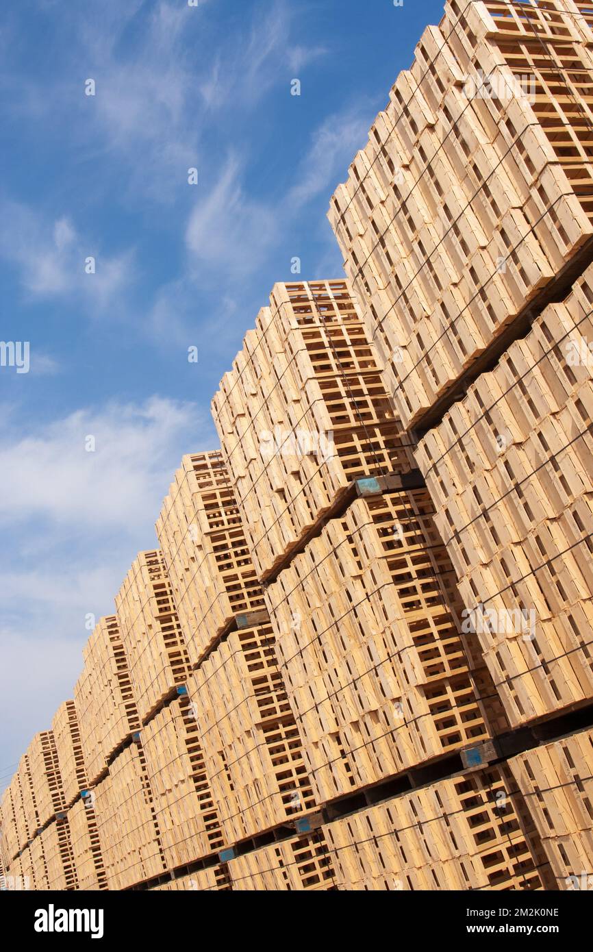 A vertical shot of a stack of wooden pallets in a warehouse cargo ...
