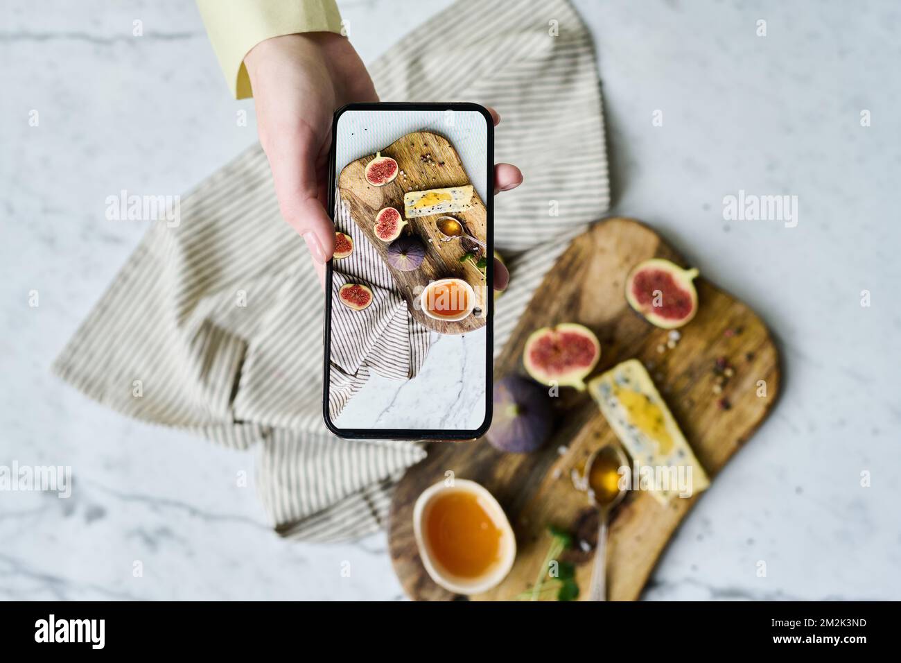 High angle view of photographer taking picture of food on tray using ...