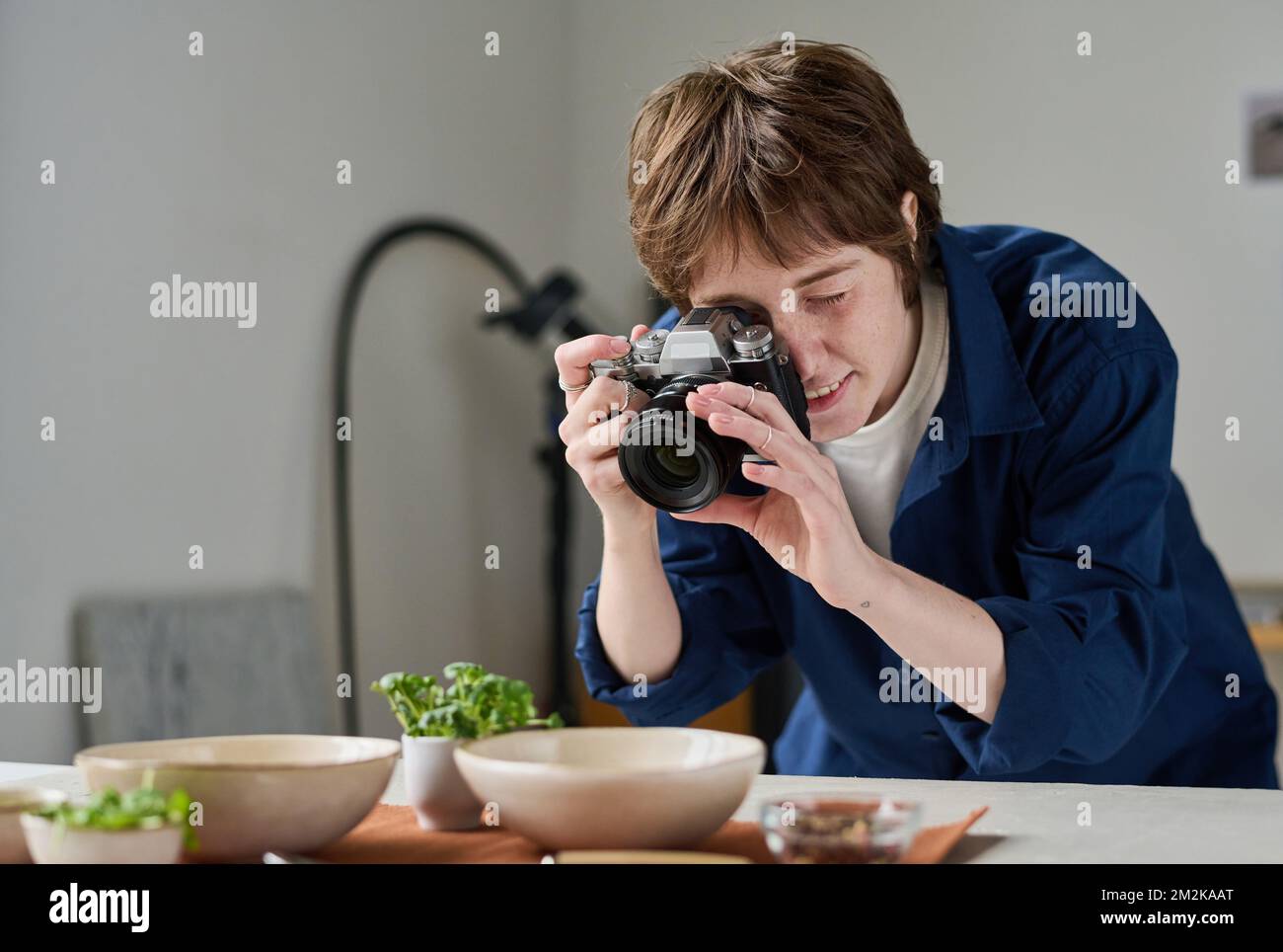 Young smiling woman taking picture of food using her digital camera ...