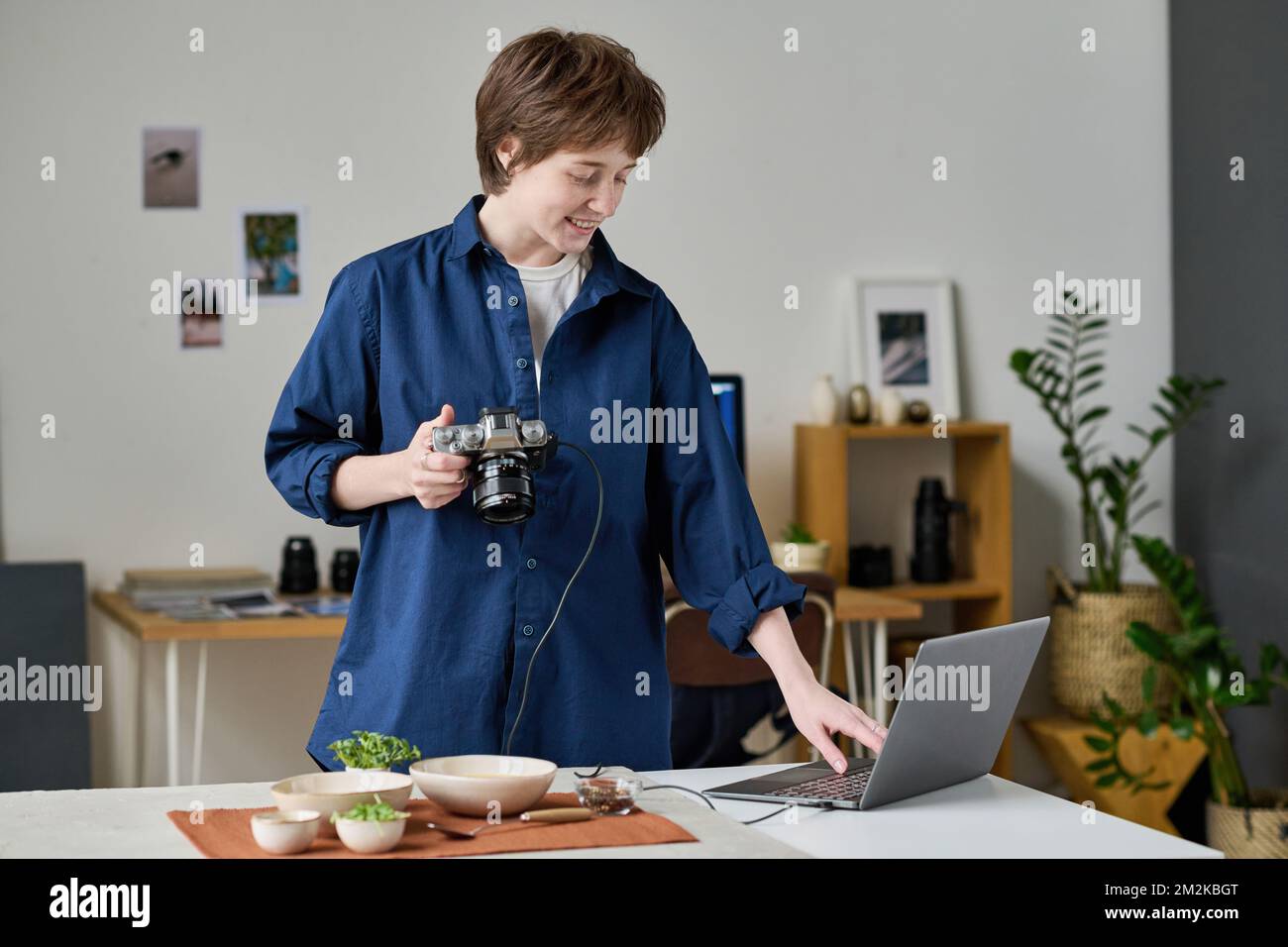Young photographer using laptop during shooting in photo studio Stock ...