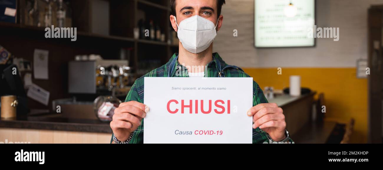 Young waiter or owner looking at camera with sad face wearing mask. Guy ...