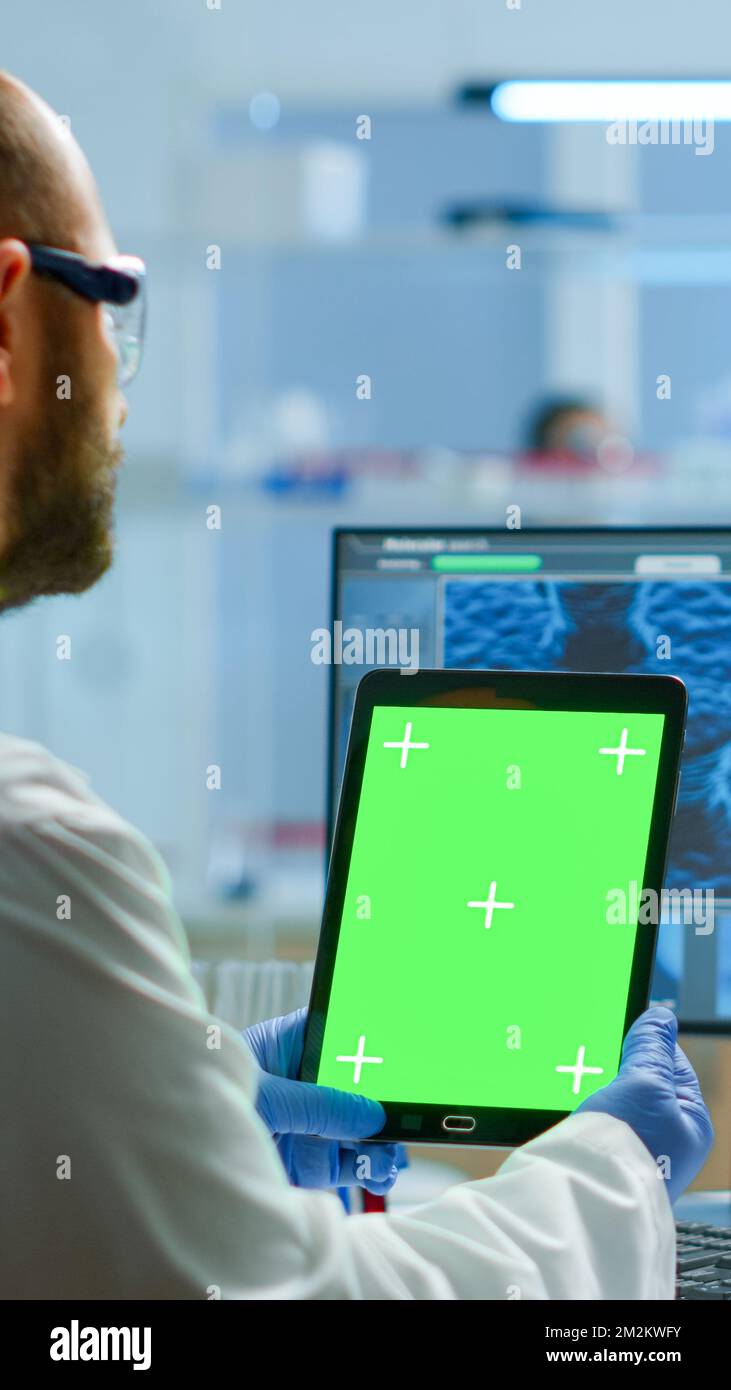 Man doctor holding tablet with green screen in modern equipped lab ...