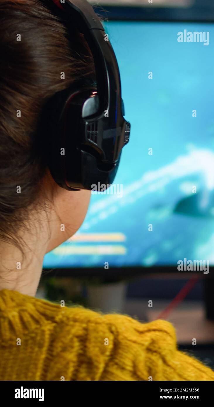 Back view of professional online gamer woman playing shooter game. Pro ...
