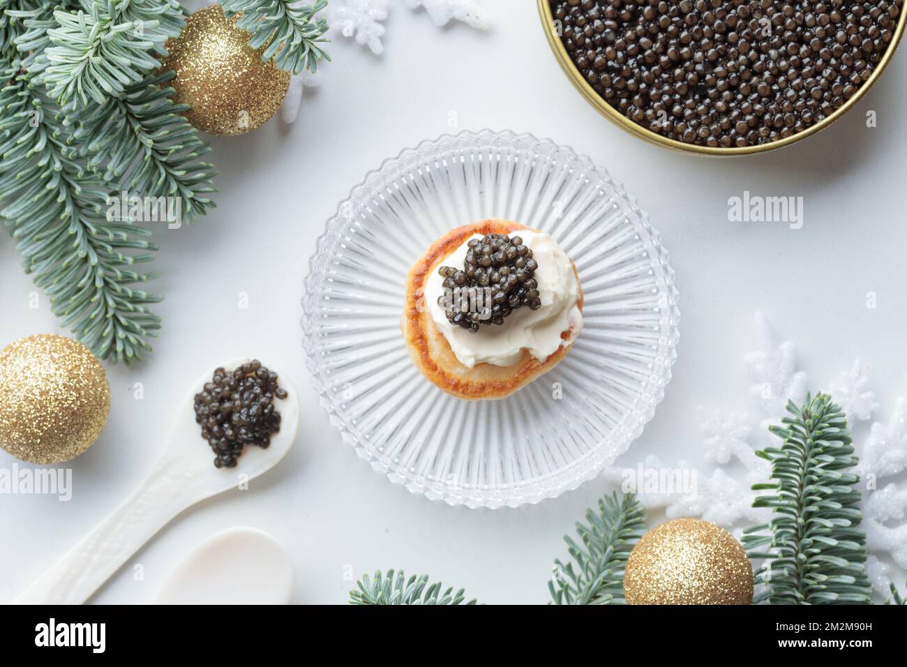 Black caviar appetizers mini pancake on a christmas decorated white ...