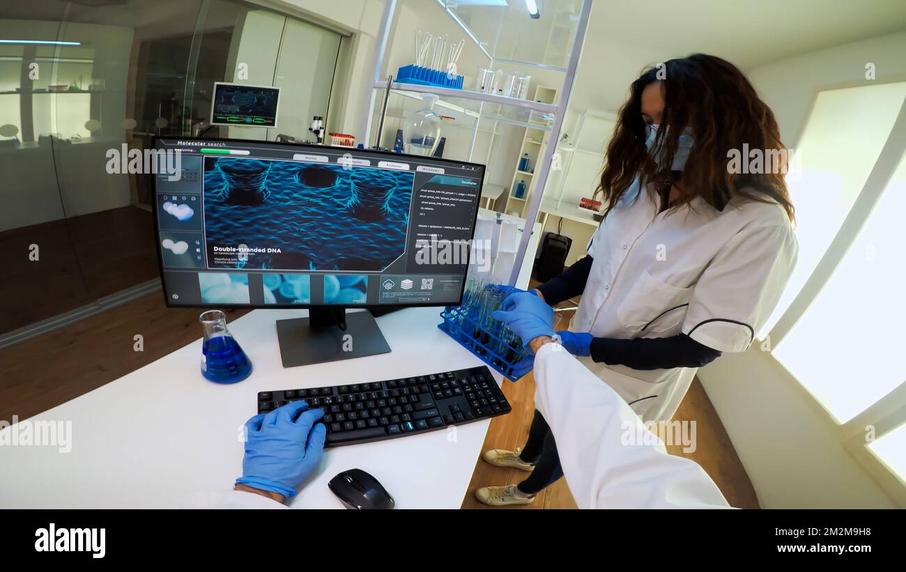 POV of researcher doctor writing at computer, analysing DNA scan image ...