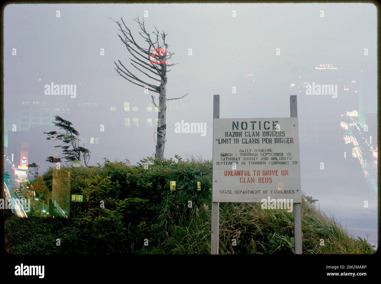 Double exposure of sign with information on razor clam digging and ...