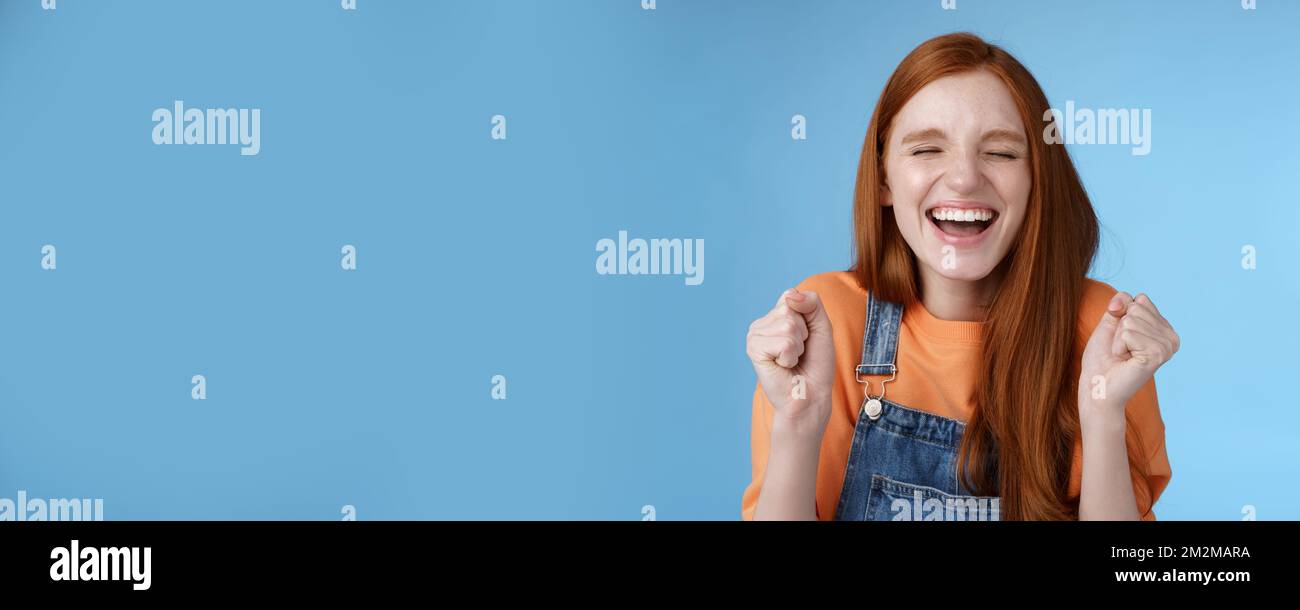 Sincere happy rejocing ginger girl close eyes smiling broadly say yes ...