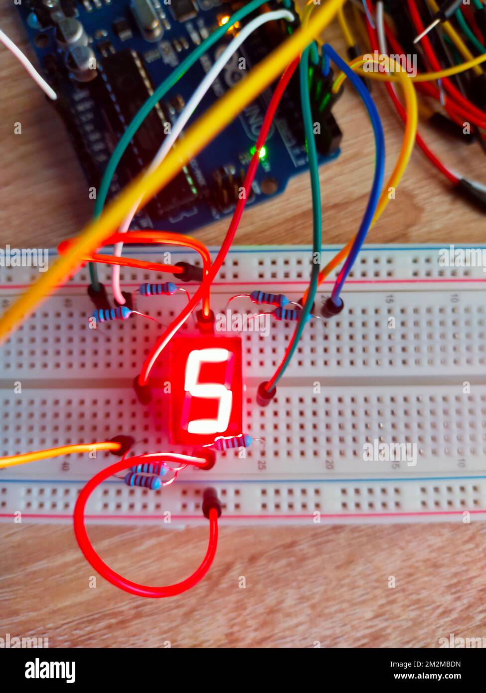 A vertical top view of number five on seven segment display breadboard ...