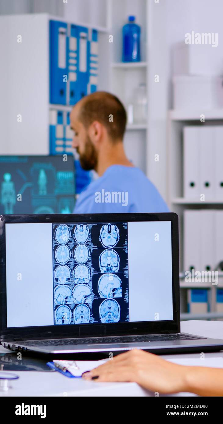Doctor assistant analyzing skull brain x-ray tommography medical data ...