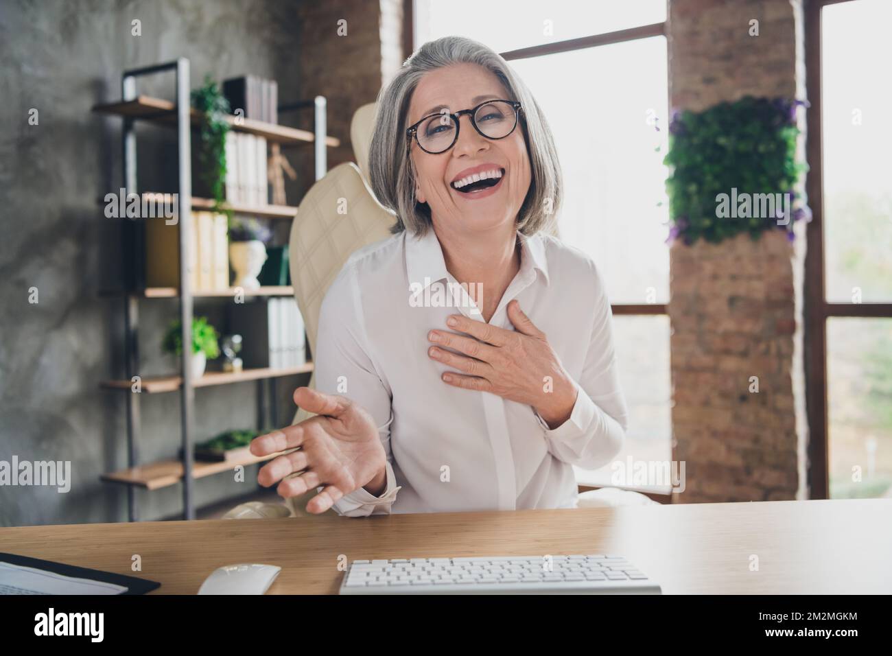 Photo of excited cheerful aged lady sit chair communicate speak video ...
