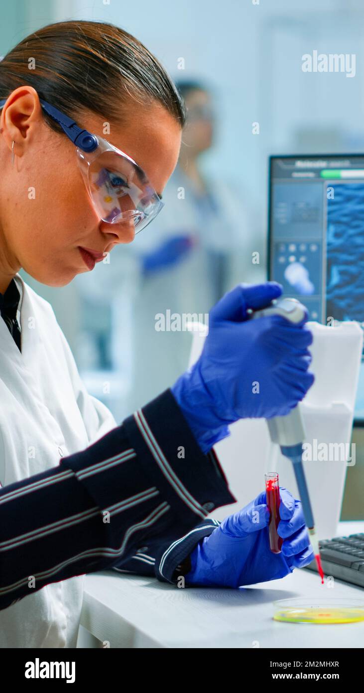 Research scientist using micropipette to extract blood sample on petri ...