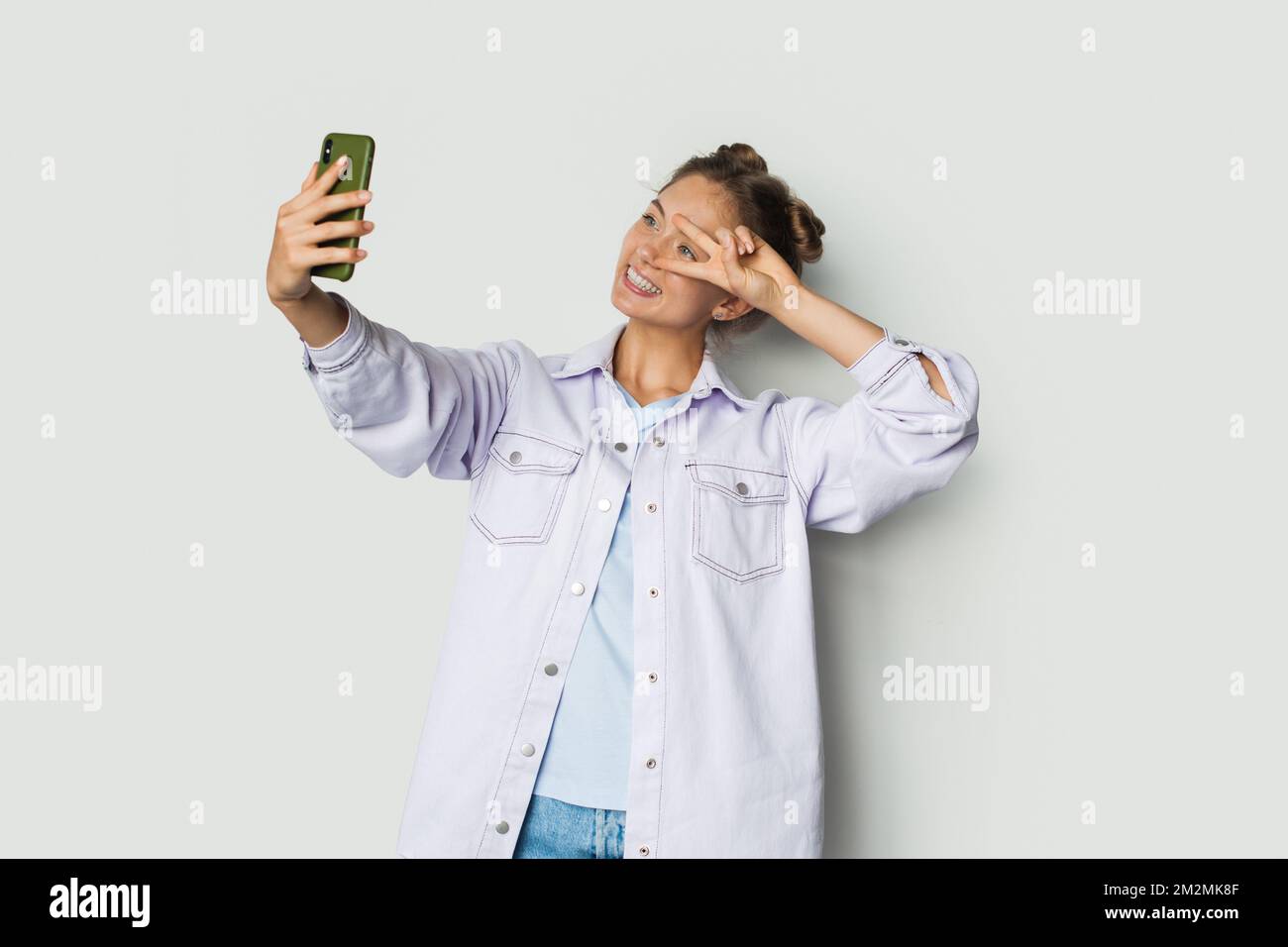 Happy expressive woman posing while taking pictures of herself through ...