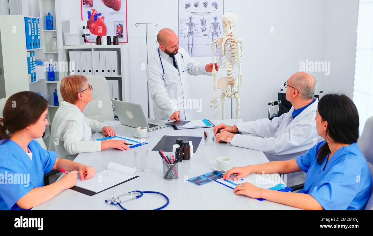 Doctor explaining radiography in front of medical staff in hospital ...