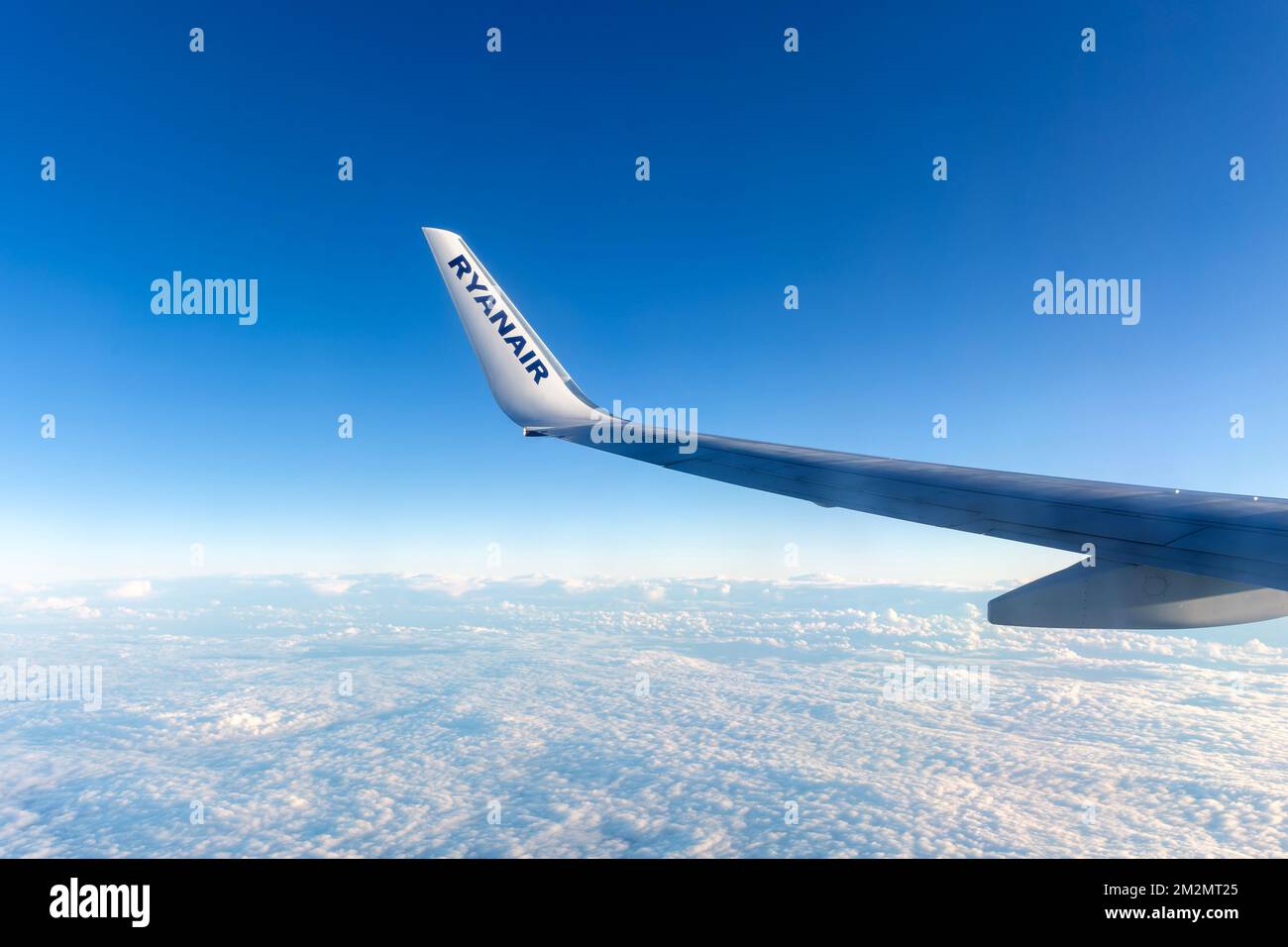 Wing of Ryanair airline Boeing 737 plane flying at high altitude above ...