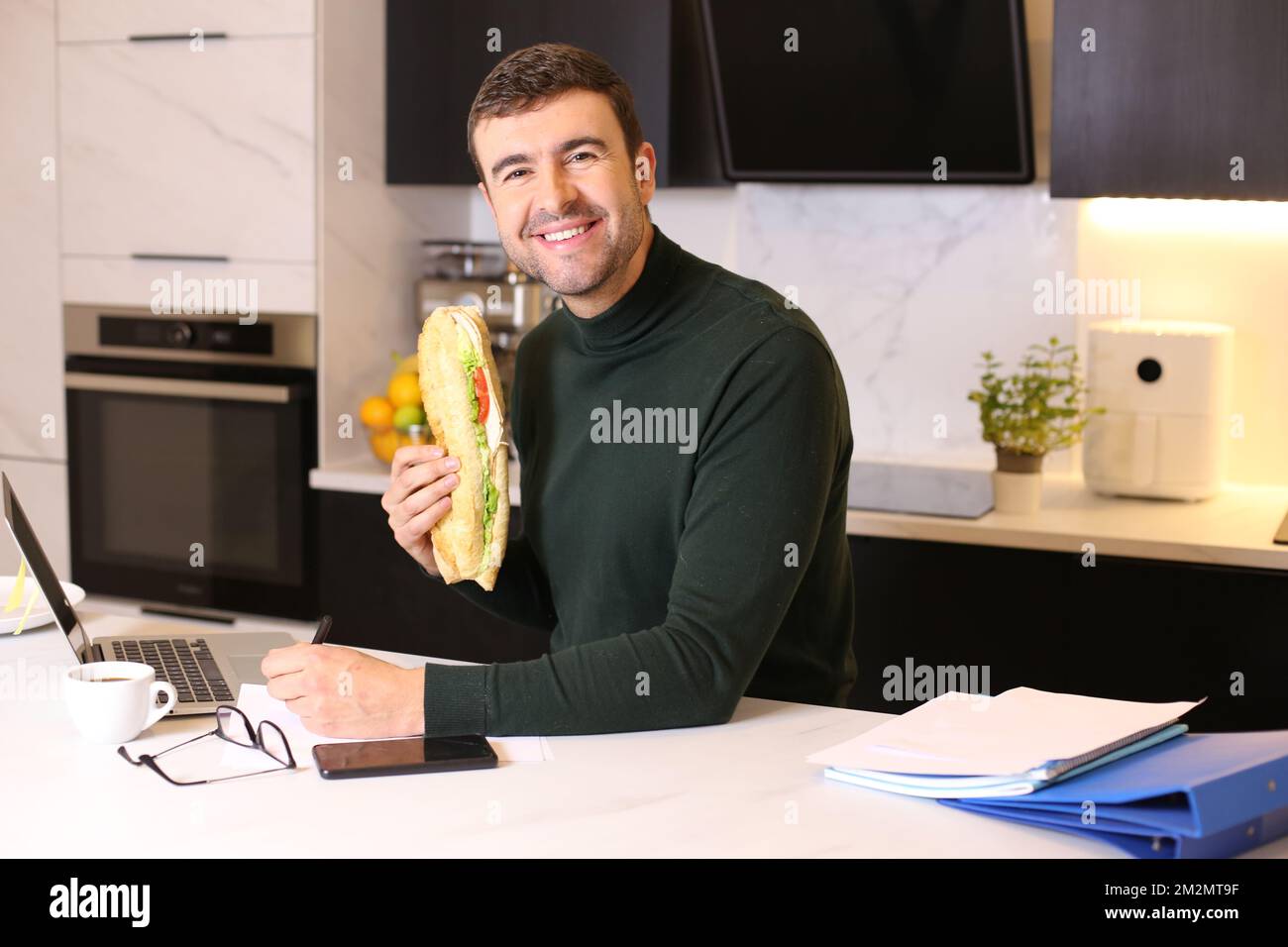 Worker eating a very large sandwich in home office Stock Photo - Alamy
