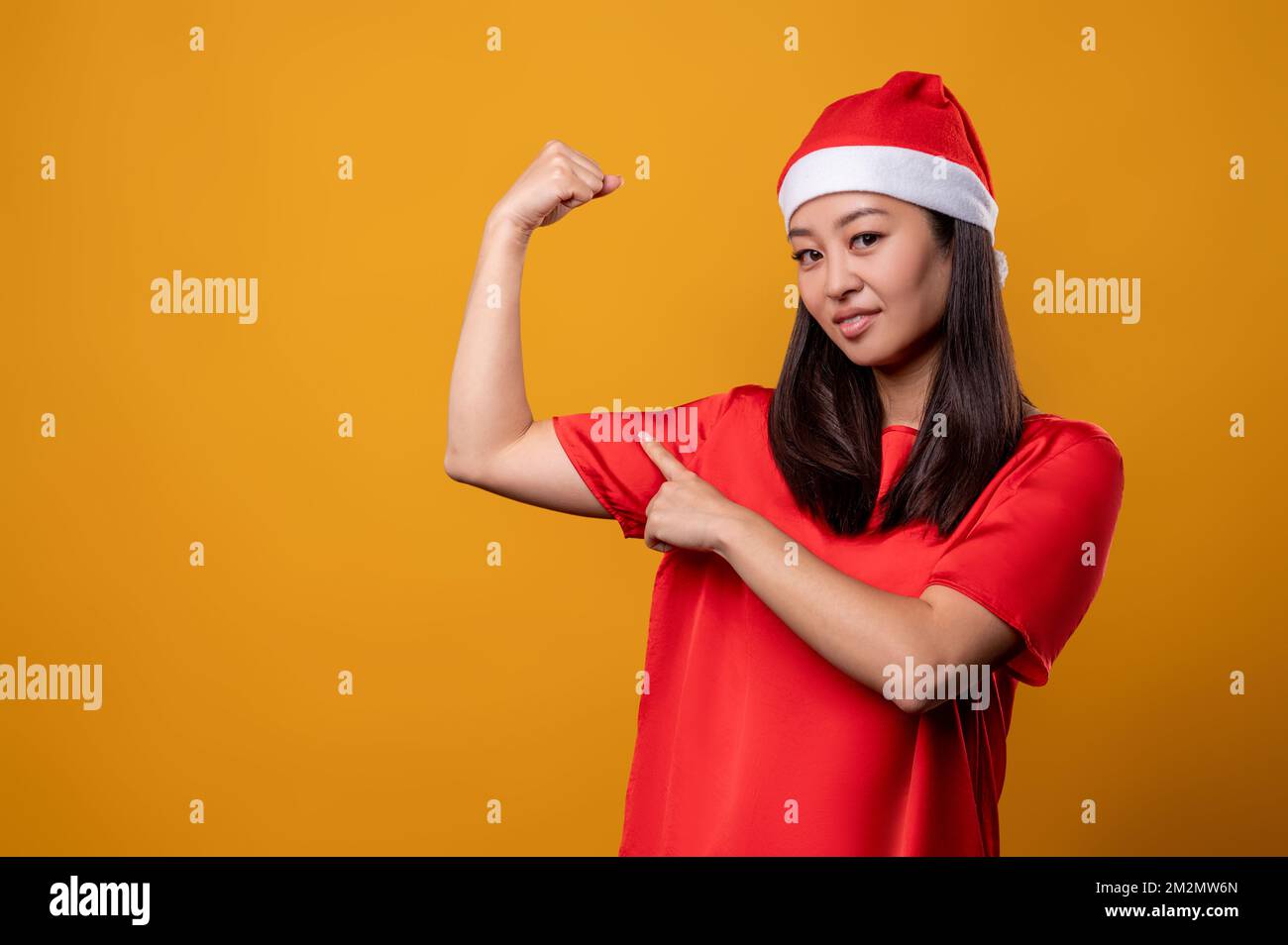 Cute young woman in red showing her muscles and looking determined ...