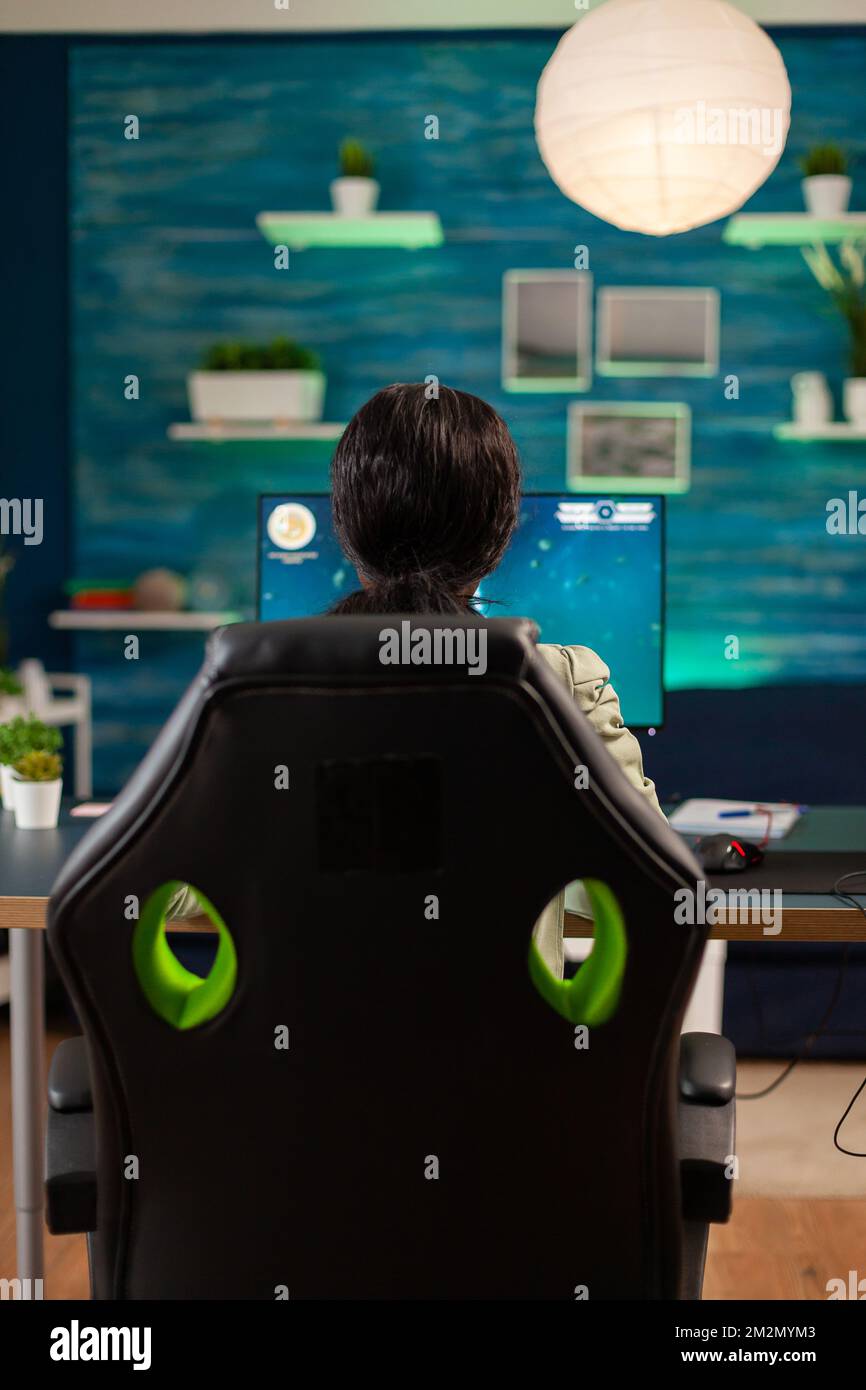 Back view of black woman playing online space shooter game. Competitive ...