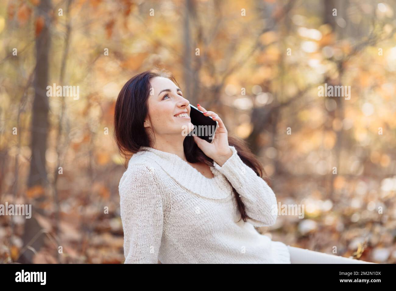 girl talks on the phone and looks away. portrait of a girl in autumn ...
