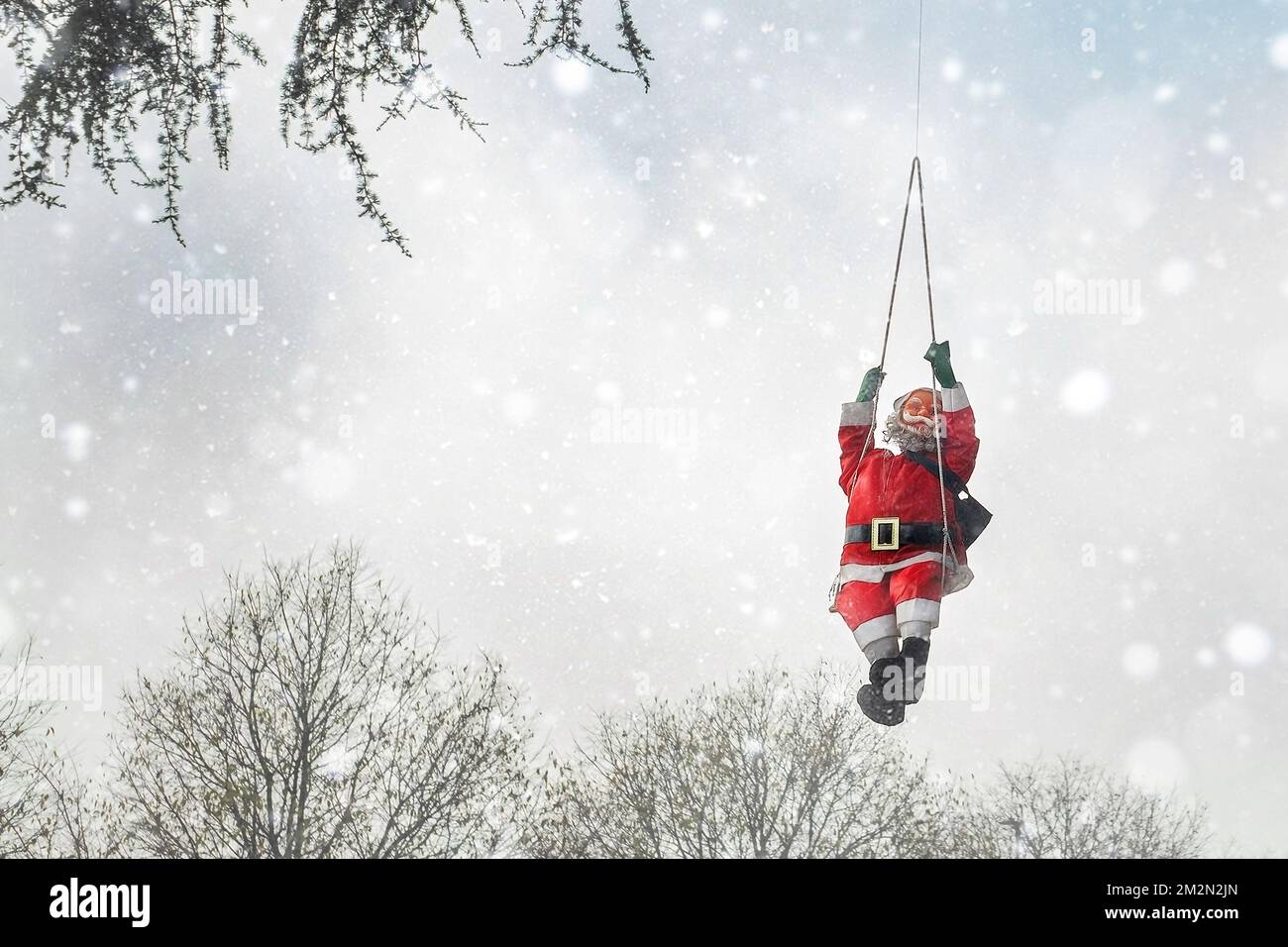 toy Santa Claus in the air on a rope on snow background. Italy Stock ...