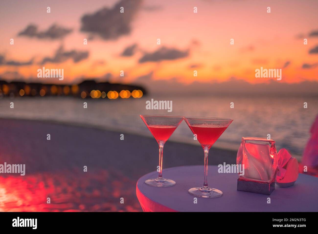 Two cocktail drinks with blur beach and colorful sunset sky in the ...