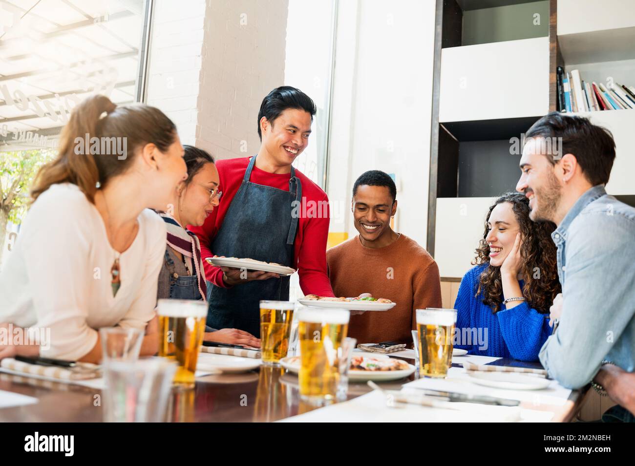 Mixed group of young friends in restaurant with smiling happy faces ...