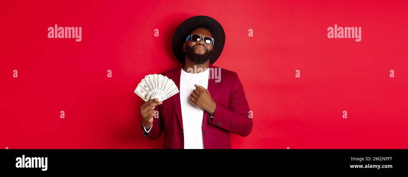 Sassy and cool african american man in sunglasses and hat, pointing at ...