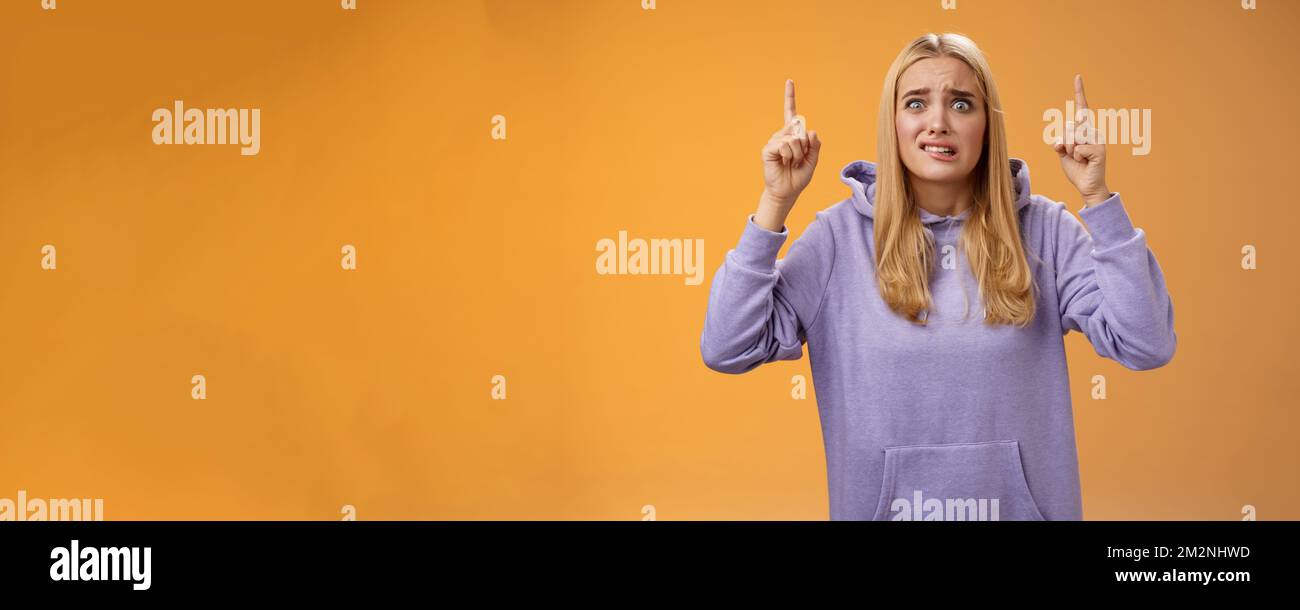 Worried perplexed unsure cute blond woman presenting project standing ...