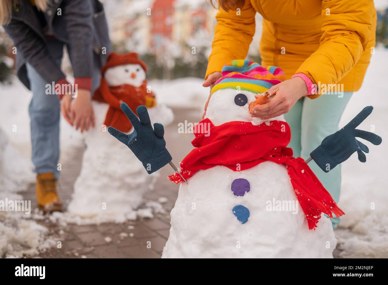 Two faceless Caucasian women are making a snowman. Winter fun Stock ...
