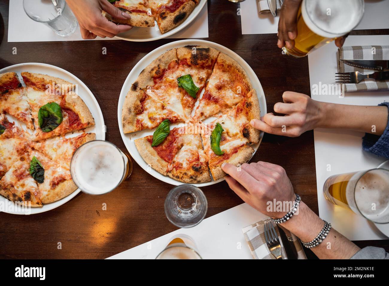 Top view restaurant table with Italian Margherita pizza and glasses of ...