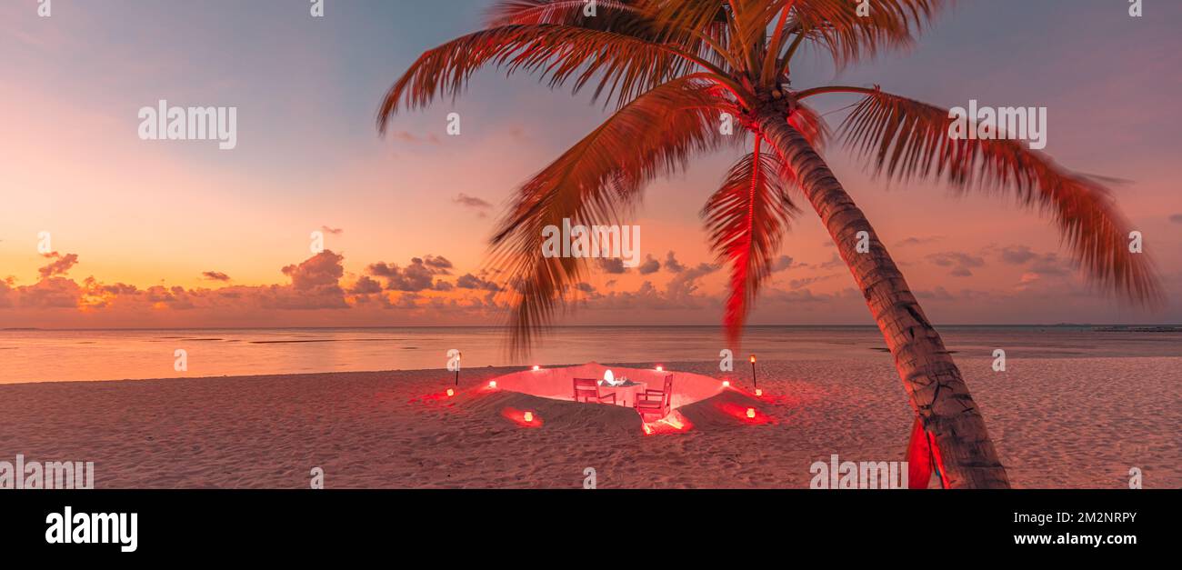 Romantic dinner on the beach with sunset, candles with palm leaves and ...