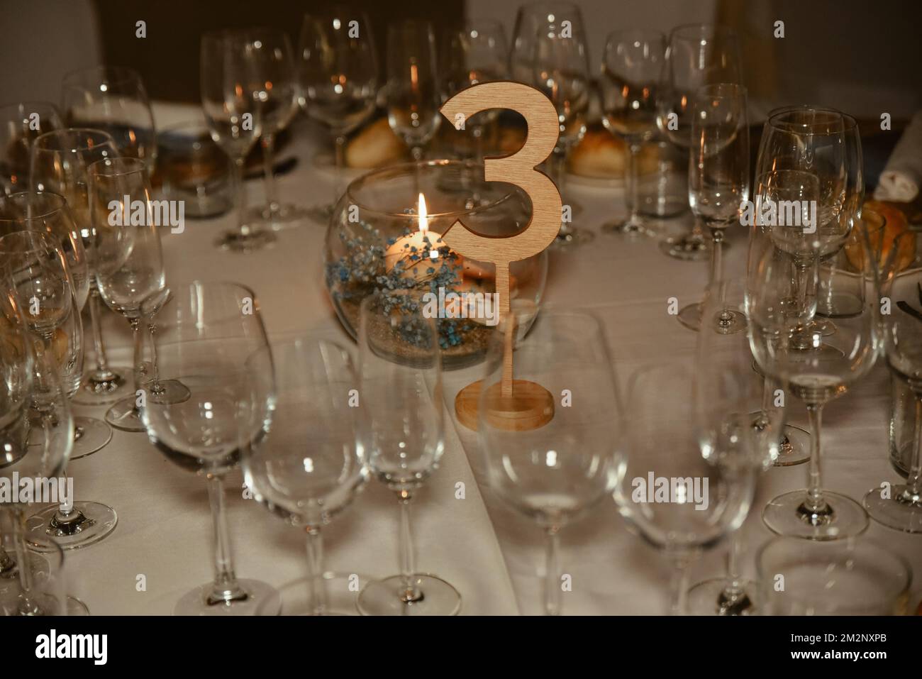A closeup shot of wine glasses on a dinner table at a party with a ...