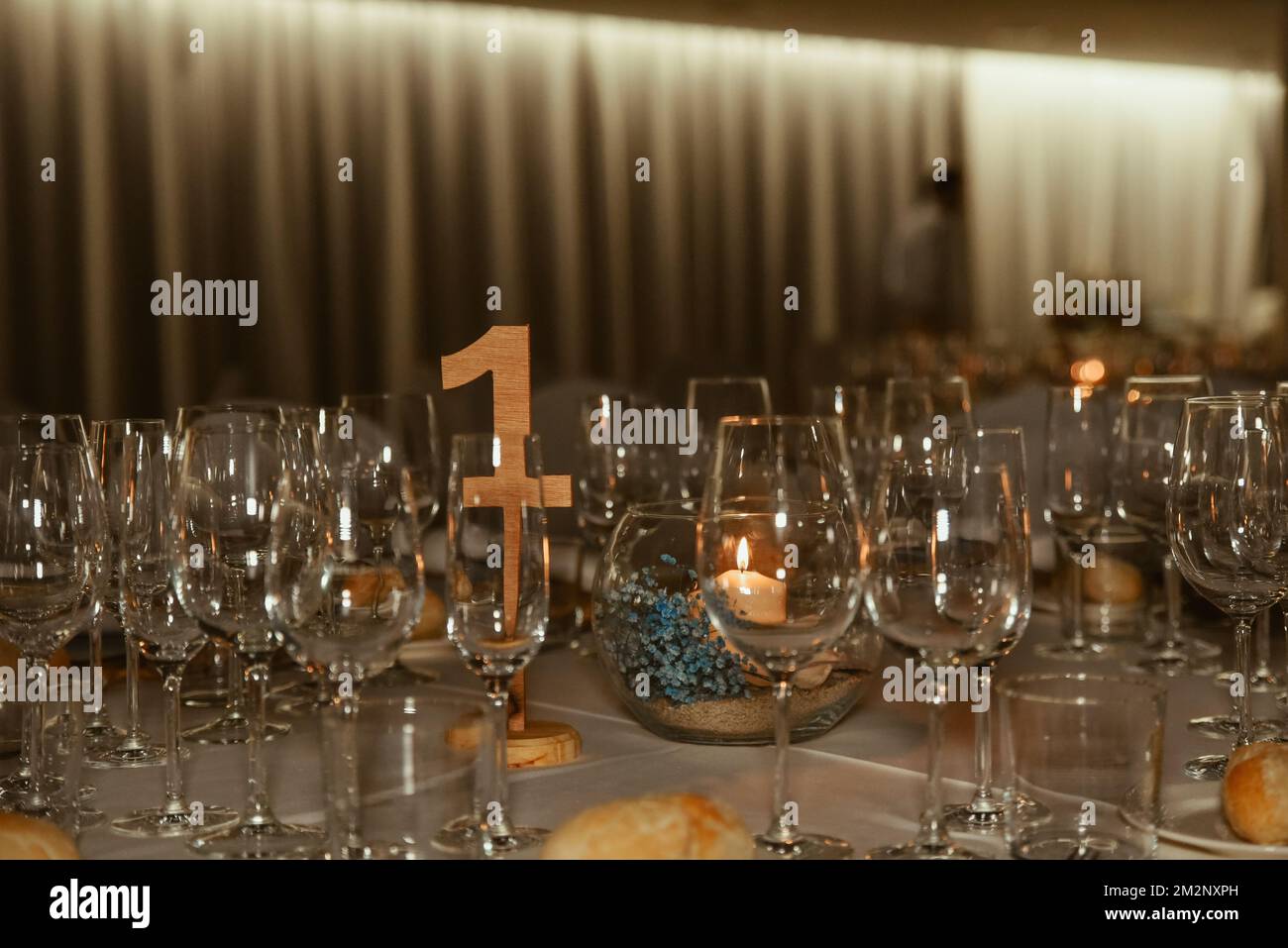 A closeup shot of wine glasses on a dinner table at a party with a ...