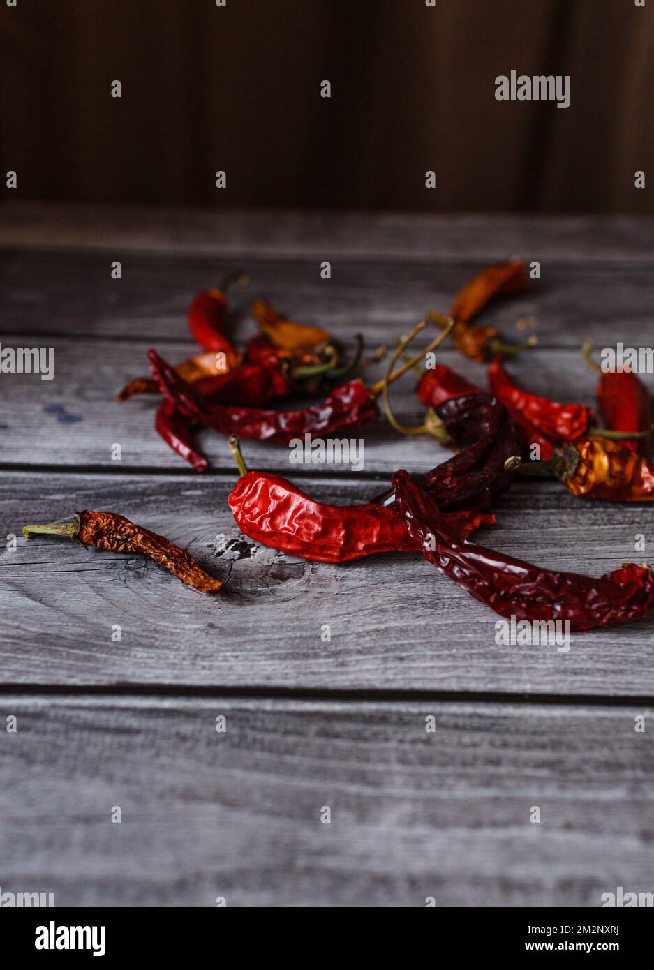 dried red chili pepper on wooden background Stock Photo - Alamy