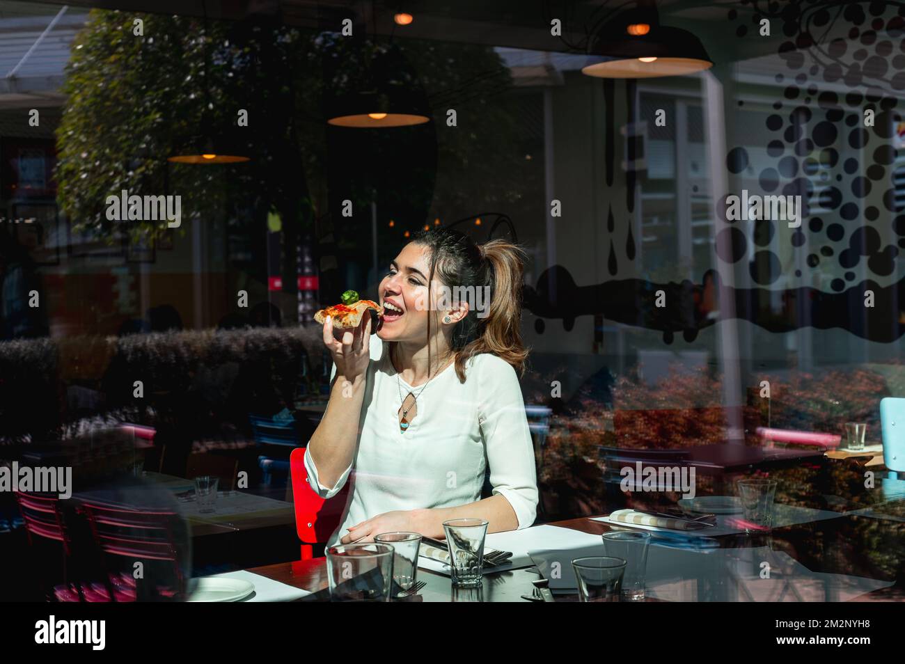 Shot Behind A Window Glass Young Female Sitting At Table In Restaurant