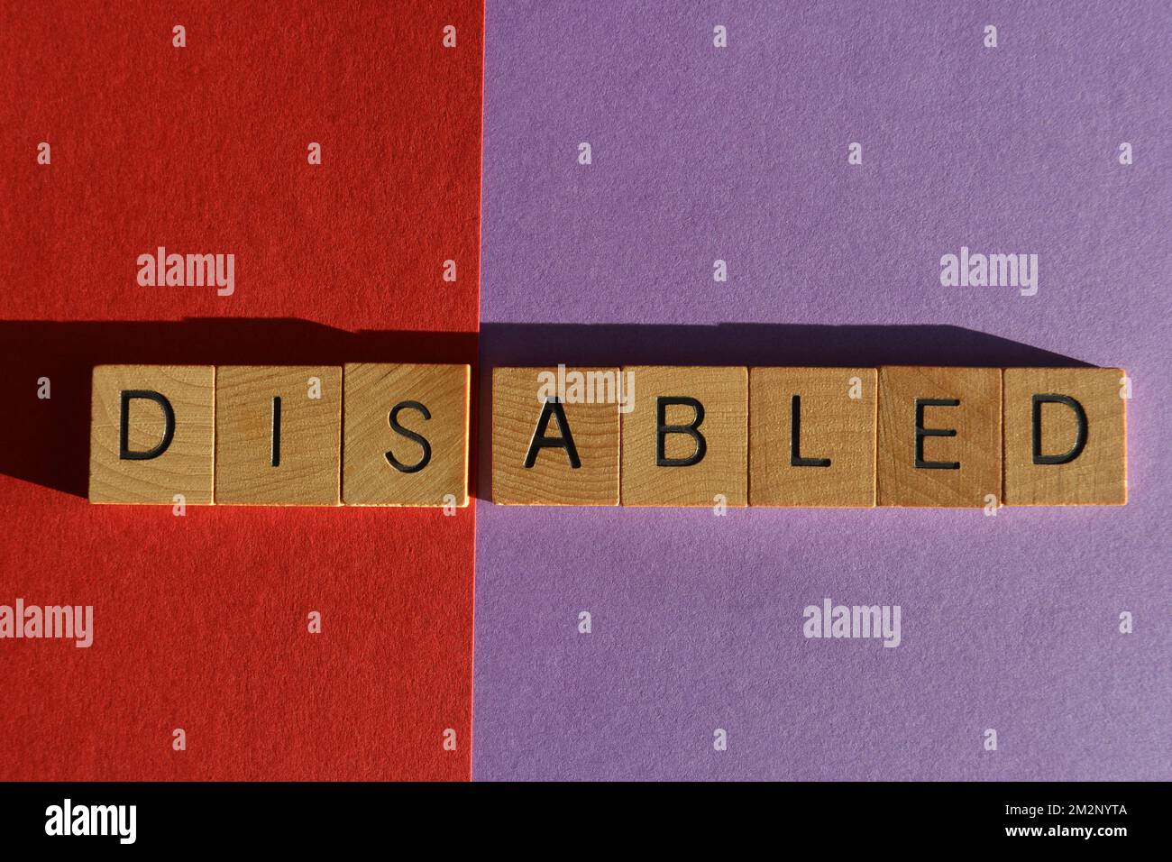 Disabled, word in wooden alphabet letters isolated on red and purple ...