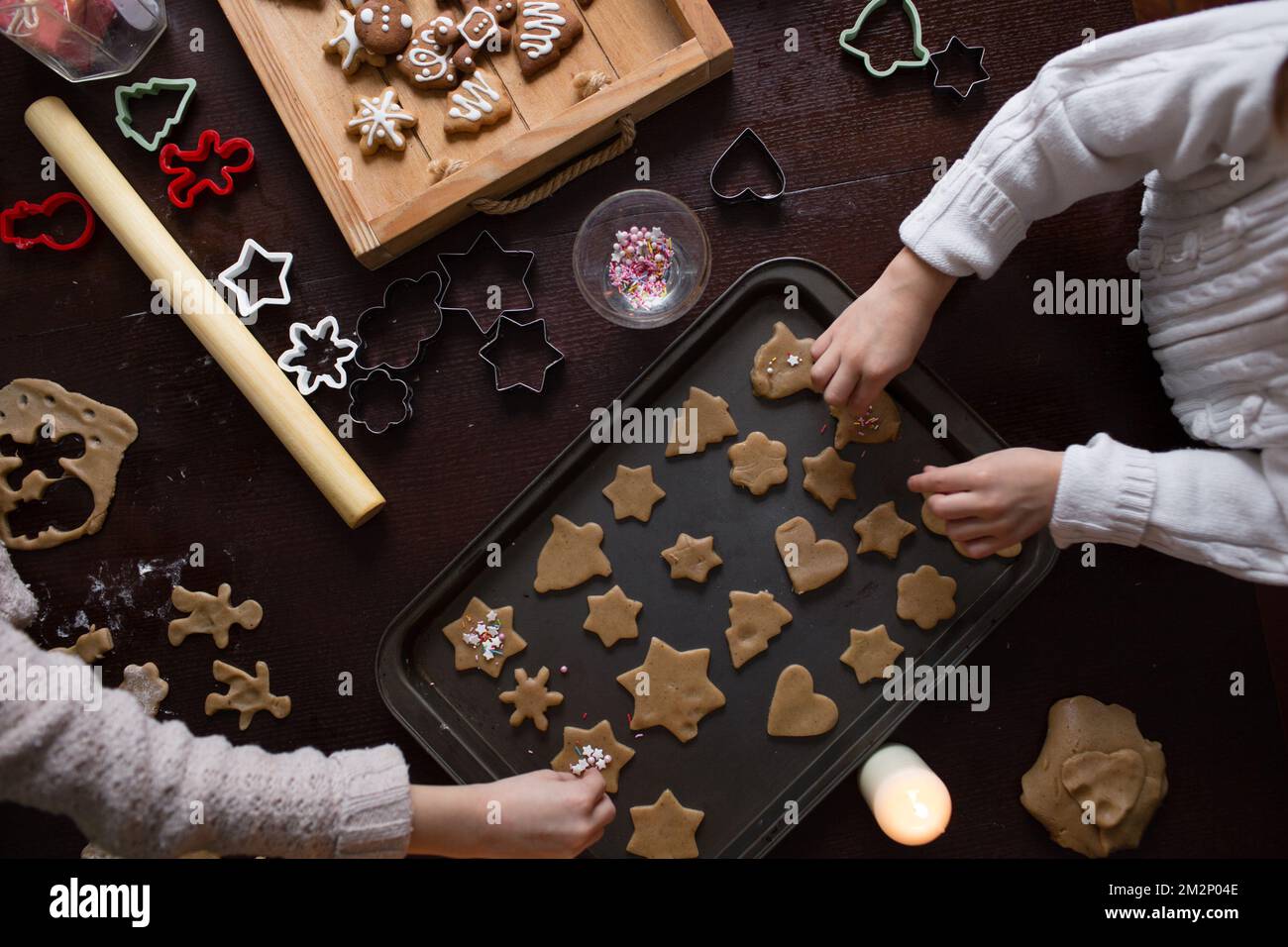 charming girls cook Christmas cookies together at home at the table ...