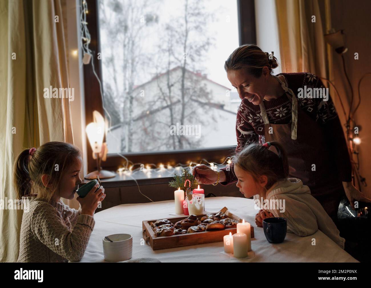 a caring mother treats young children with delicious Christmas buns ...